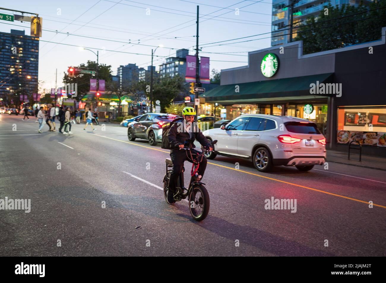 Food delivery riders on electric bikes ride through VancouverÕs West ...