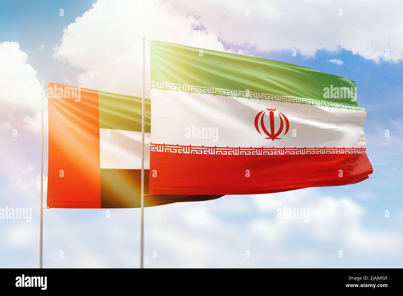 Sunny blue sky and flags of iran and uae Stock Photo - Alamy