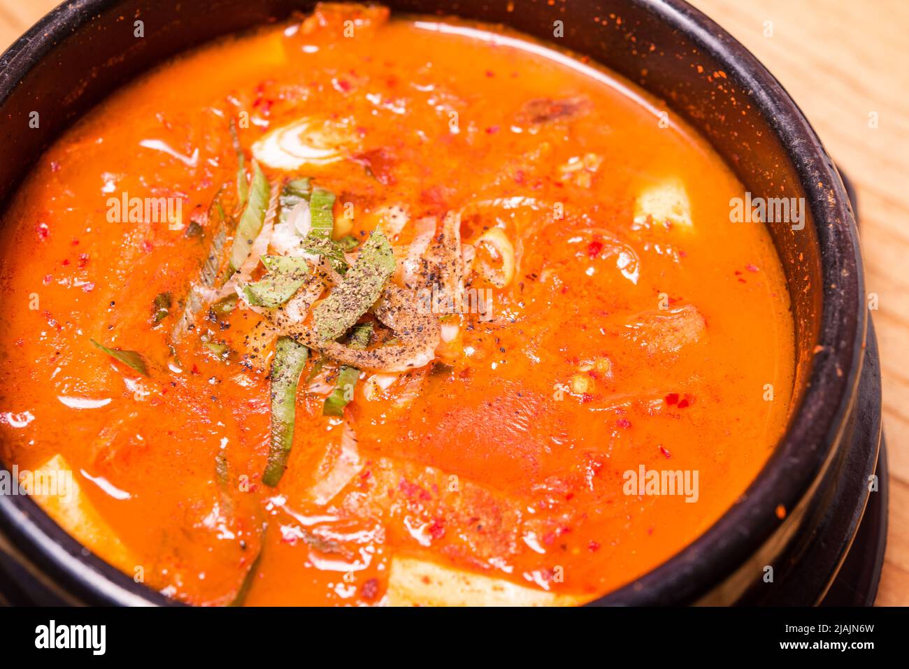 Kimchi soup in hot black iron pot, Korean traditional Kimchi Jjigae ...