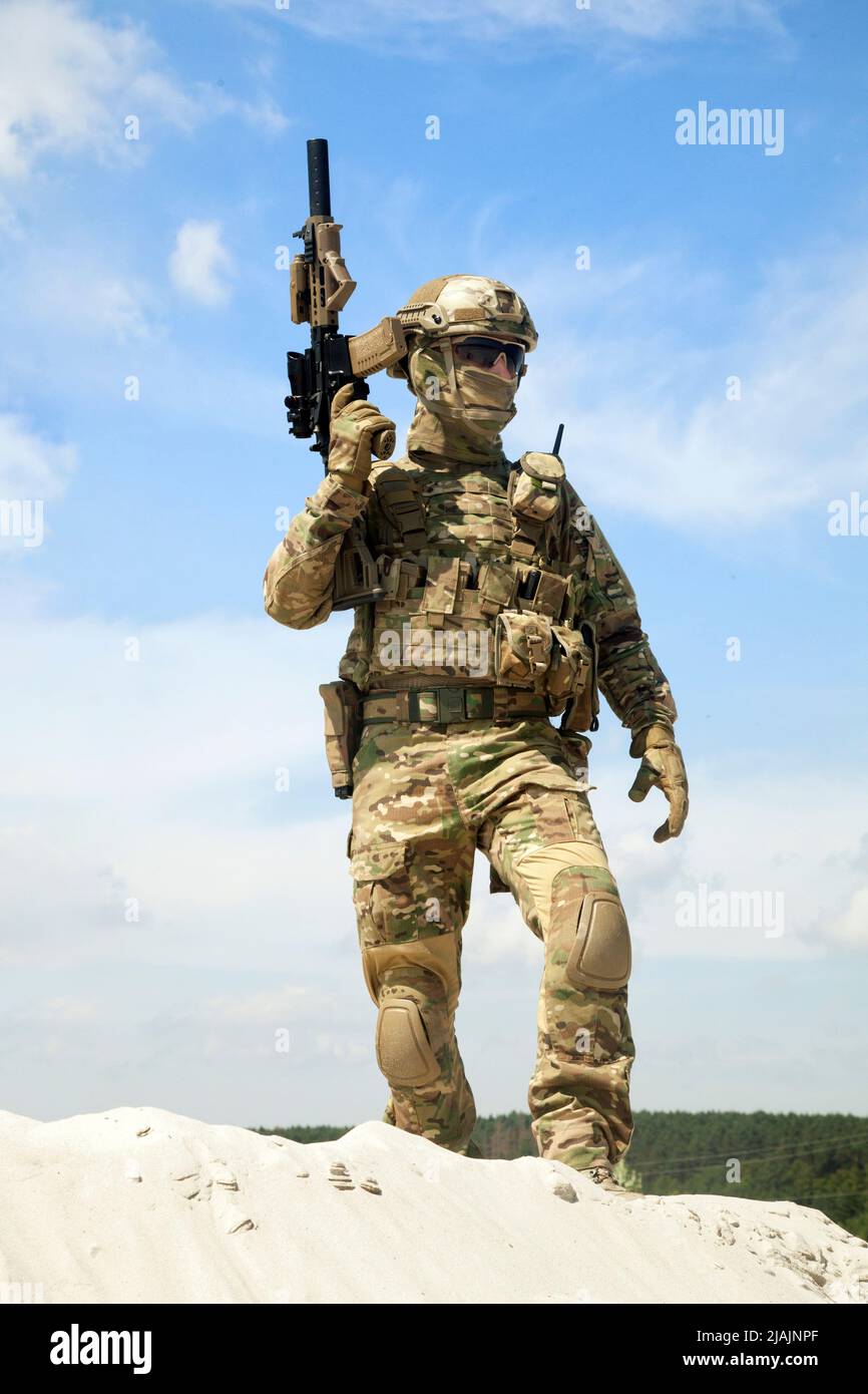 Soldier standing on sand dune with service rifle in hands Stock Photo ...