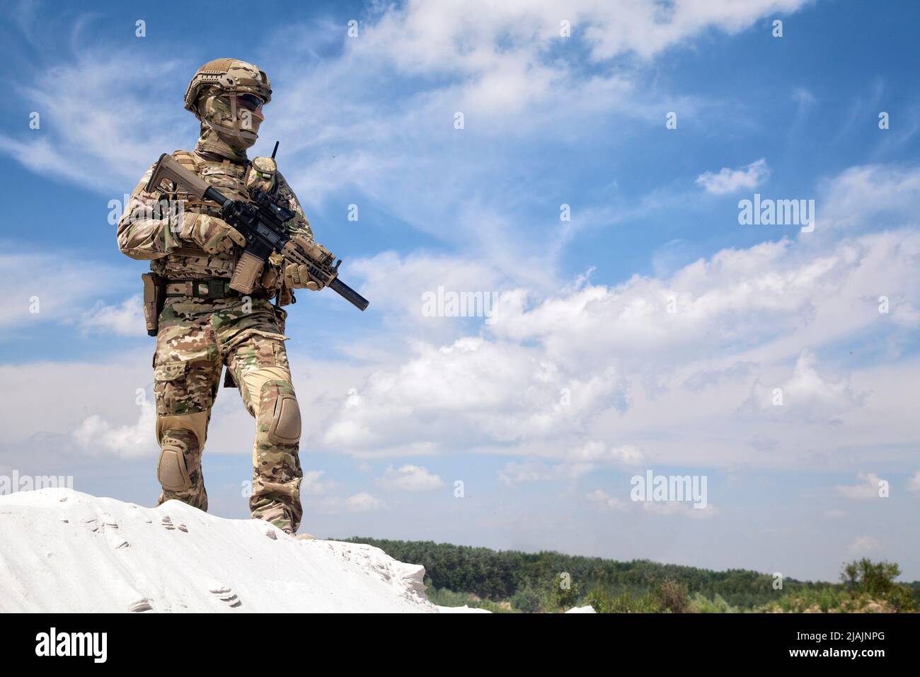 Soldier standing on sand dune with service rifle in hands Stock Photo ...
