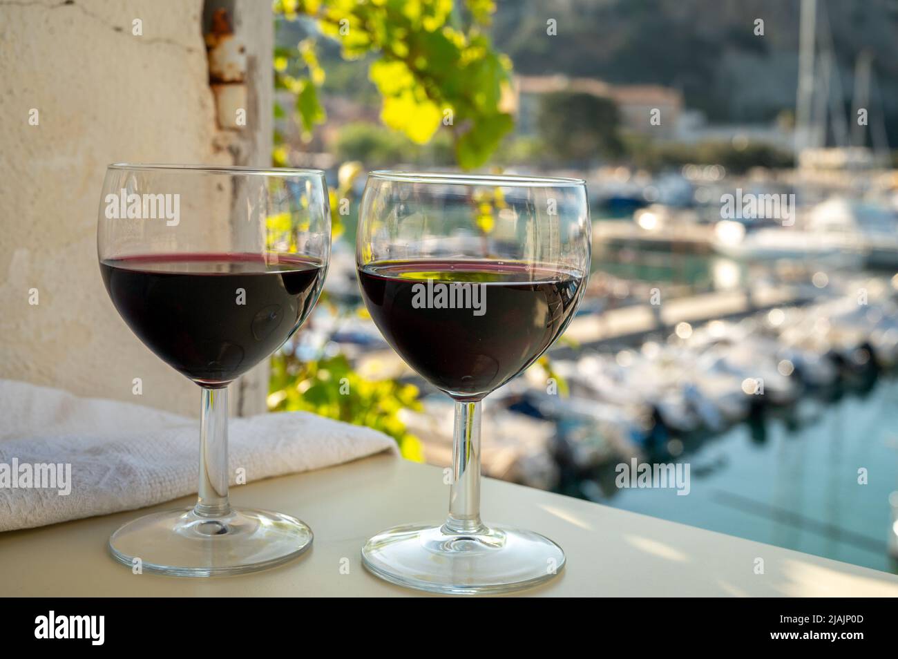 Drinking of red dry wine on outdoor terrace with view on old fisherman ...