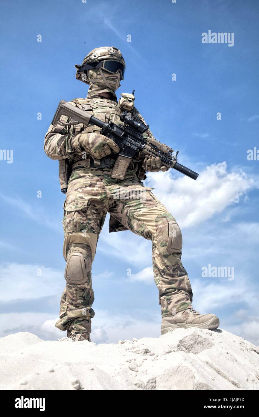Soldier standing on sand dune with service rifle in hands Stock Photo ...