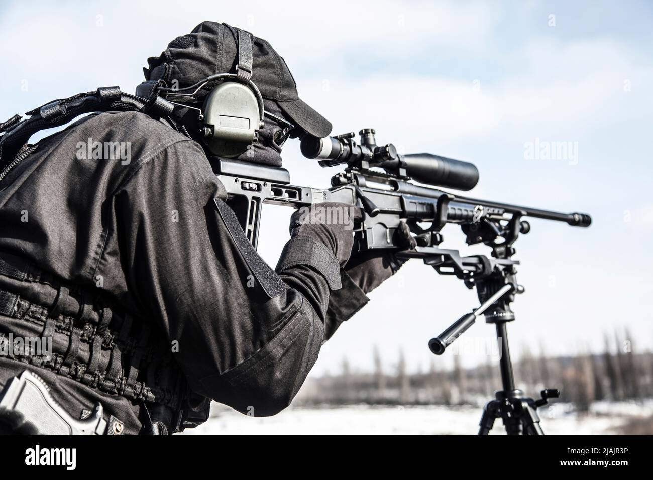 Sniper aiming with telescopic optical sight on sniper rifle mounted on ...
