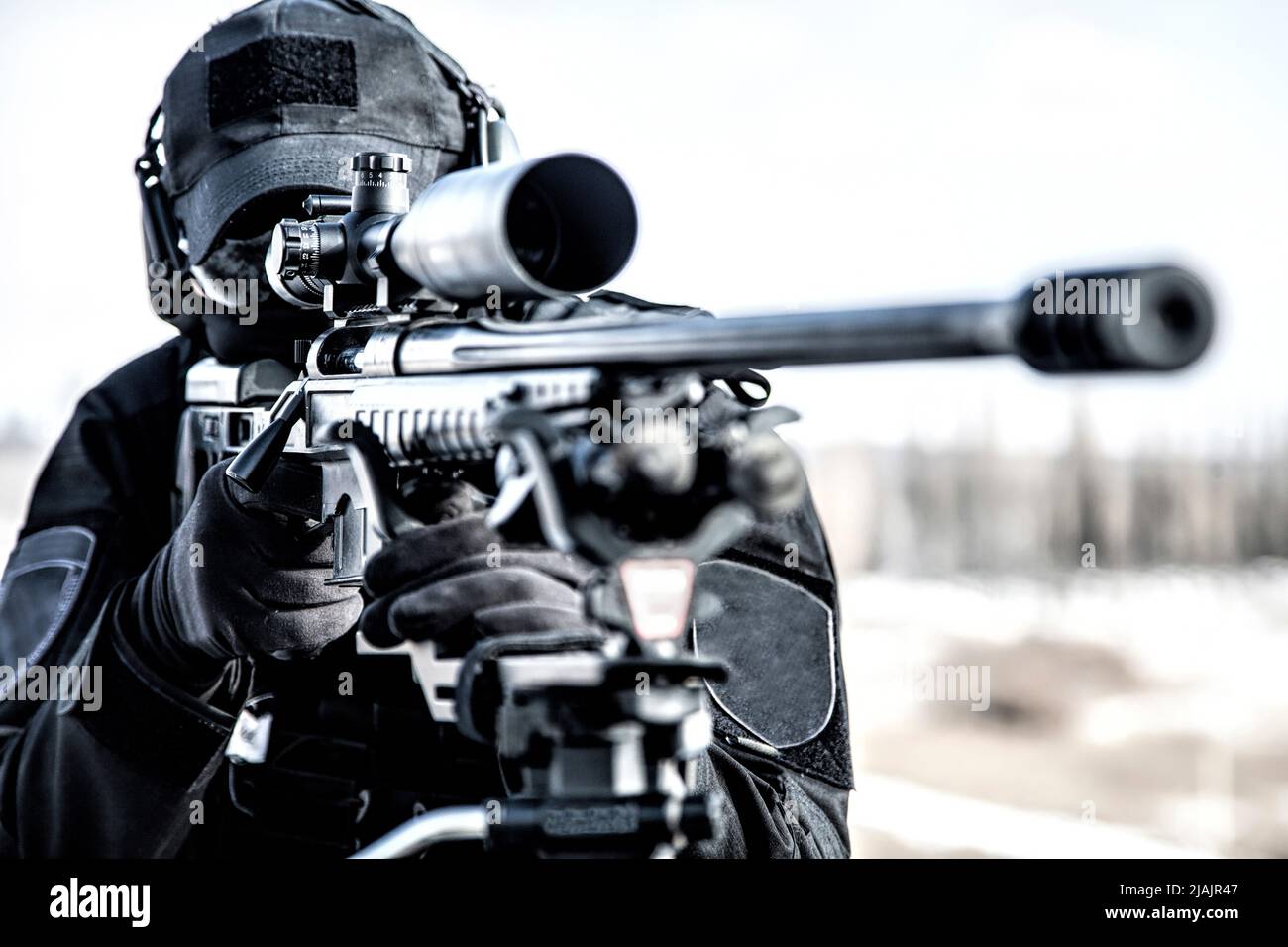 Sniper aiming with telescopic optical sight on sniper rifle mounted on ...