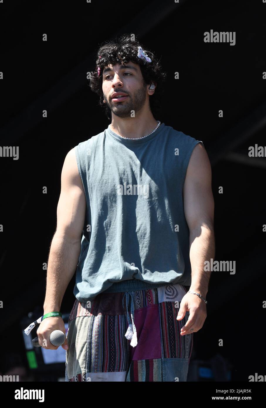 Singer Isaac Pech is shown performing on stage during a live concert ...
