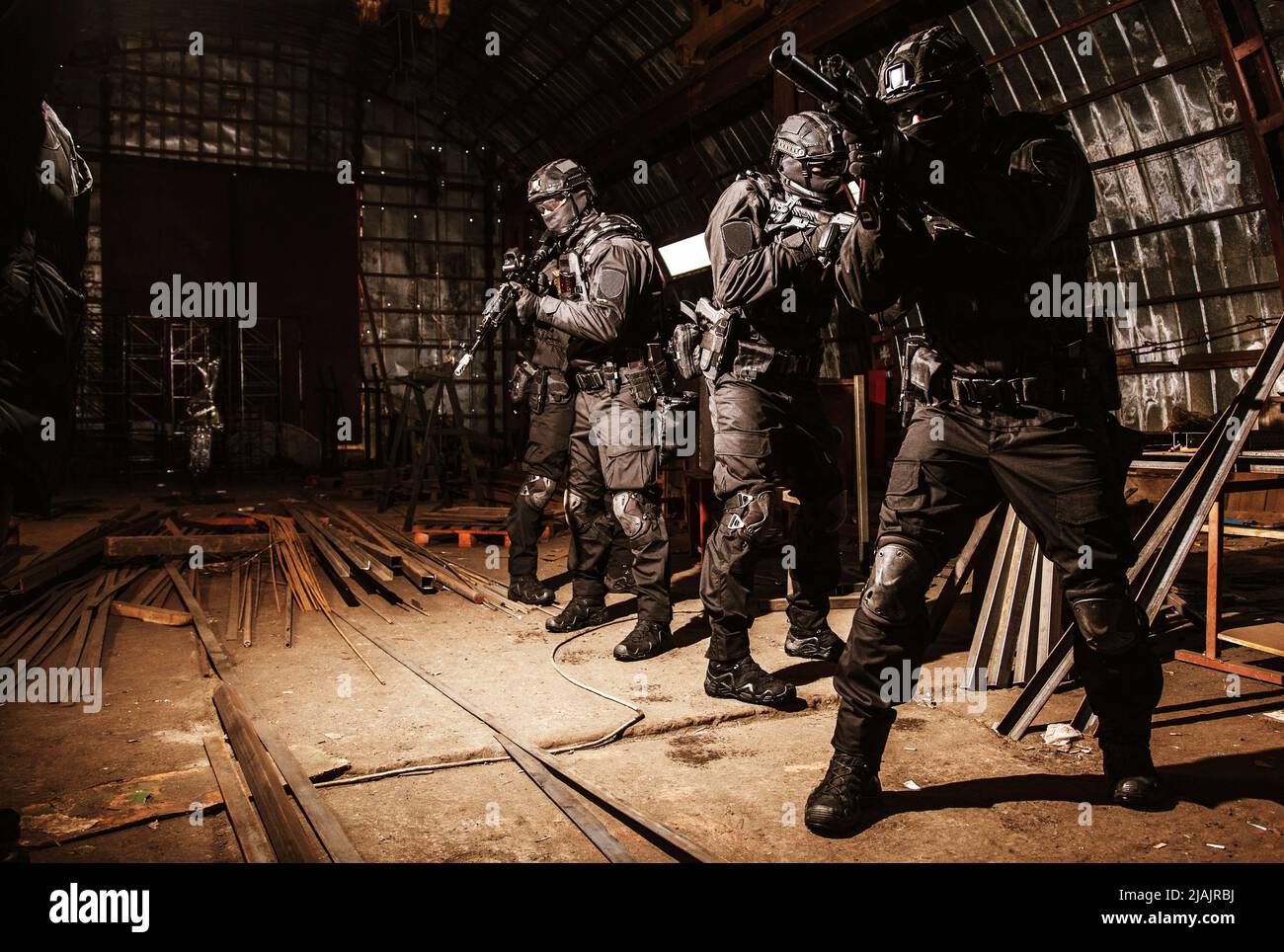 SWAT team armed with sem-automatic rifles moving with caution in an ...