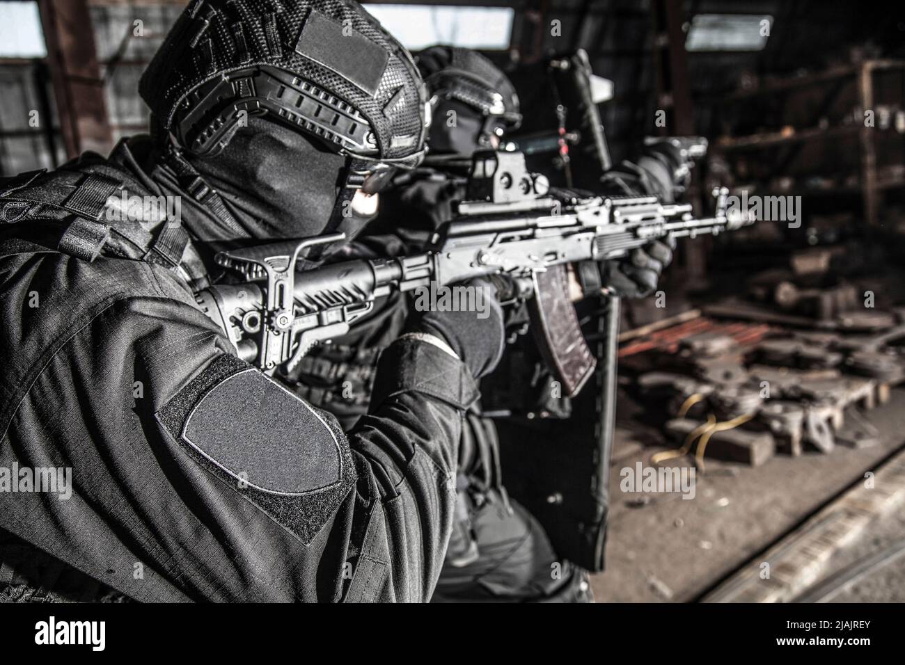 Police special reaction team aiming guns while moving forward under ...