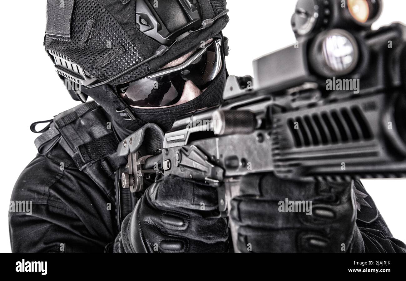 Close-up of SWAT team fighter in black uniform and helmet, aiming ...