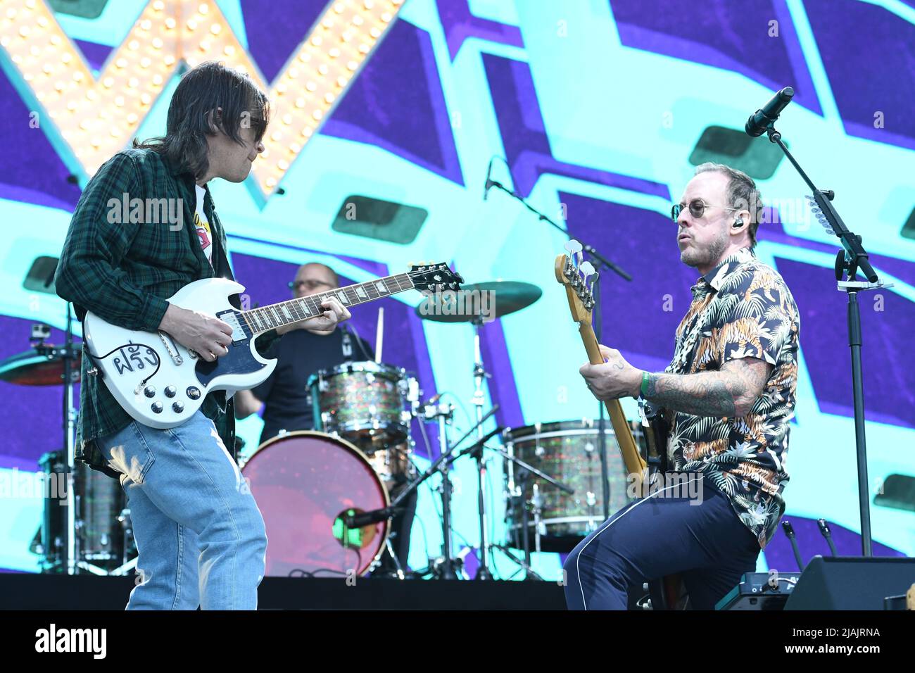 Musicians Rivers Cuomo and Scott Shriner are shown performing on stage ...