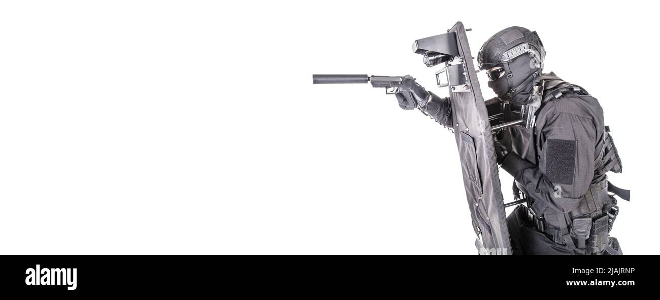 SWAT team fighter hiding behind ballistic shield and aiming pistol ...