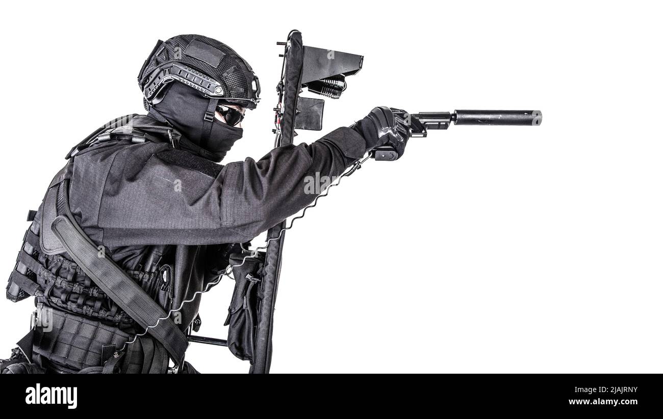 SWAT team fighter hiding behind ballistic shield and aiming pistol ...