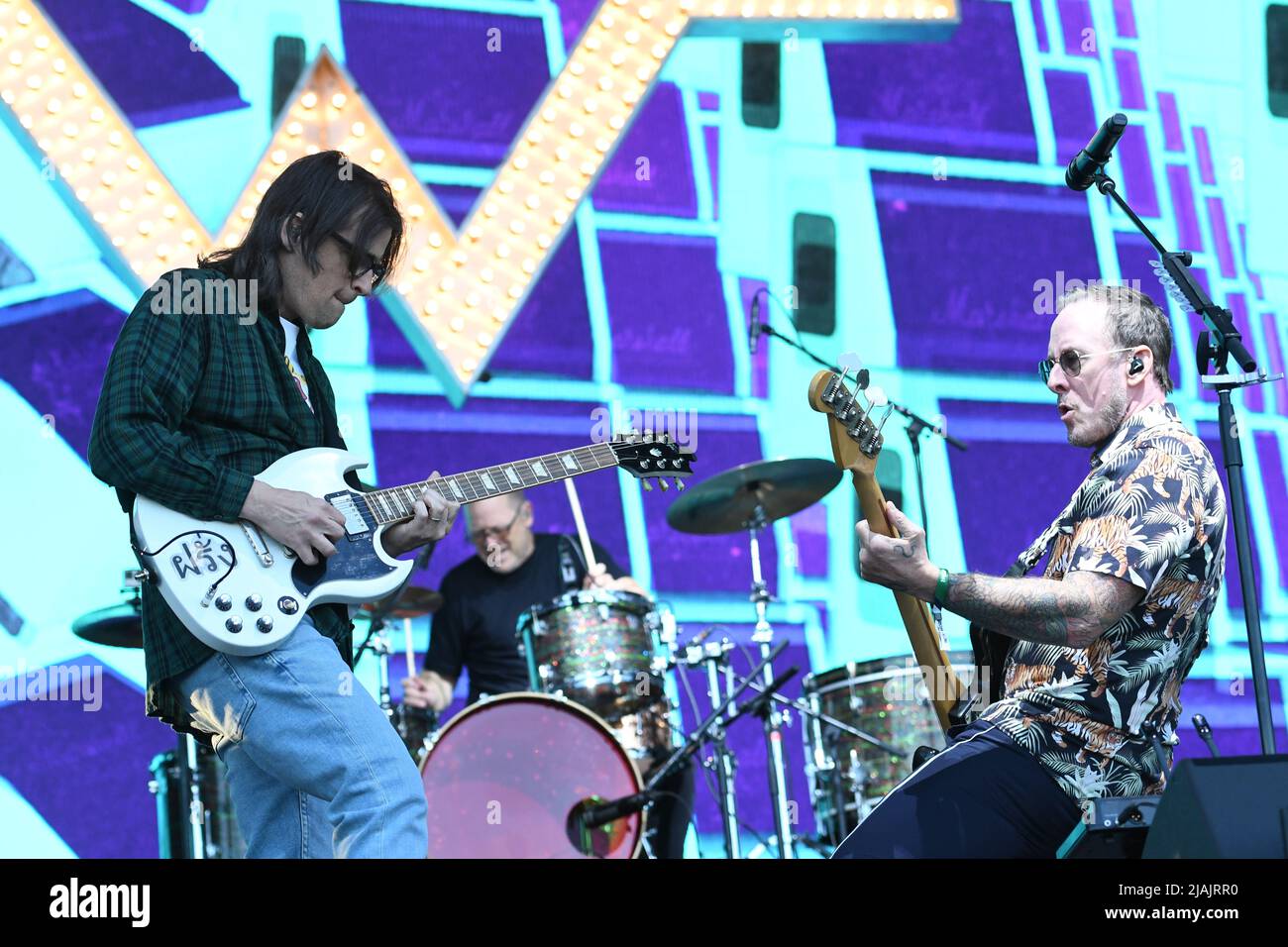 Musicians Rivers Cuomo and Scott Shriner are shown performing on stage ...