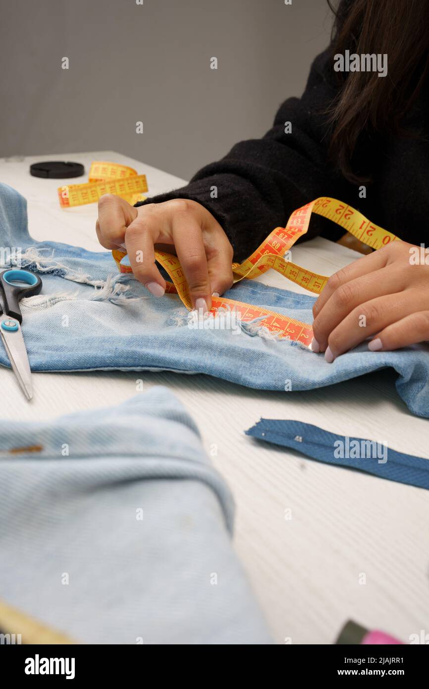 sewing workshop, measuring to repair a garment, use a tape measure ...