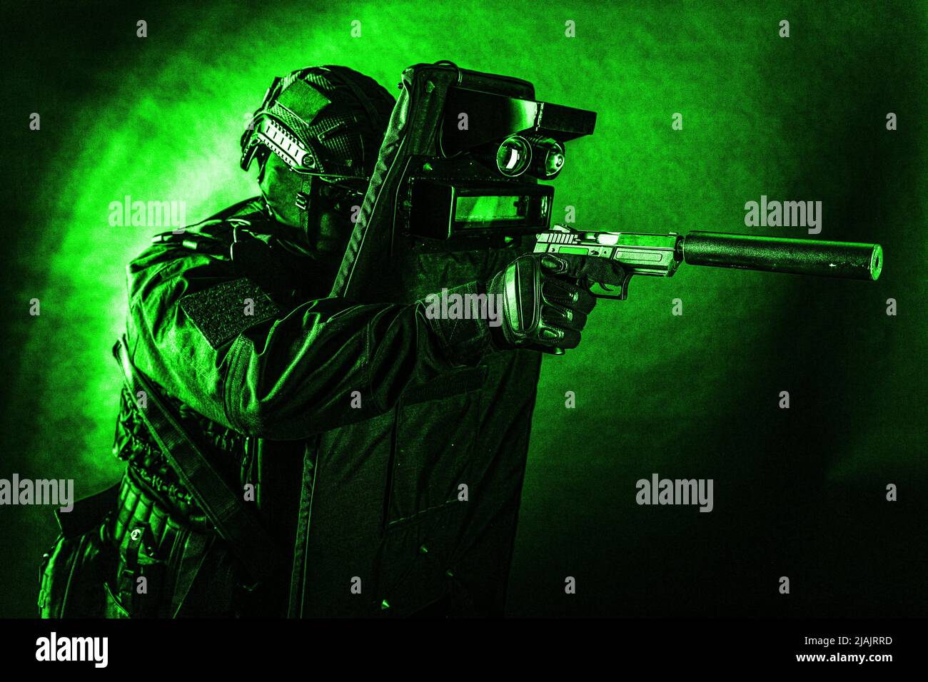 Police special operations fighter aiming pistol equipped with silencer ...