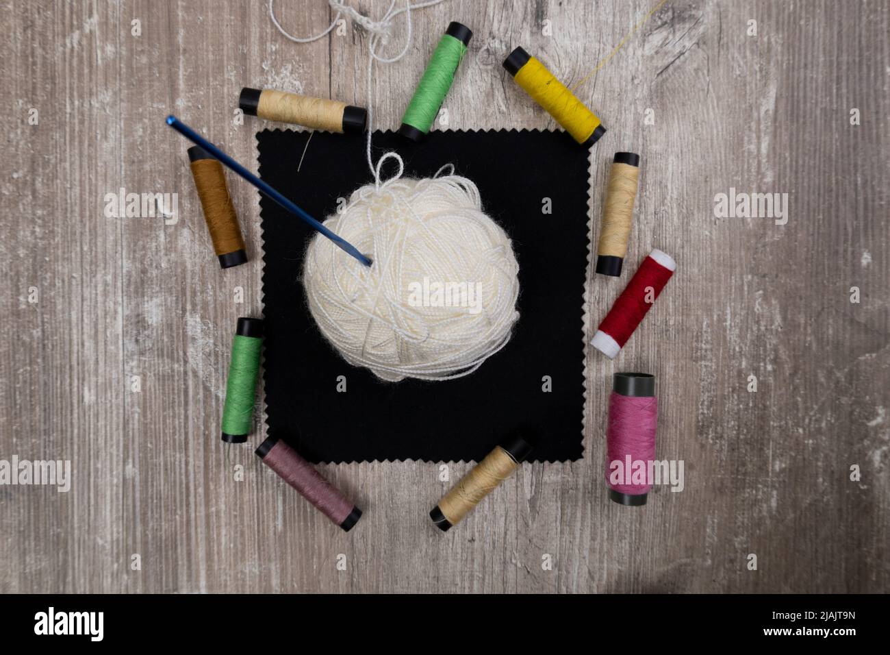 workplace wallpaper with roll of crocheted wool decorated with colored ...