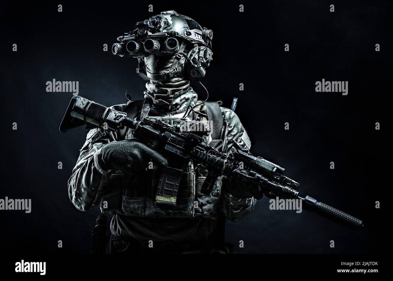 Modern combatant standing in darkness, wearing night vision device and ...