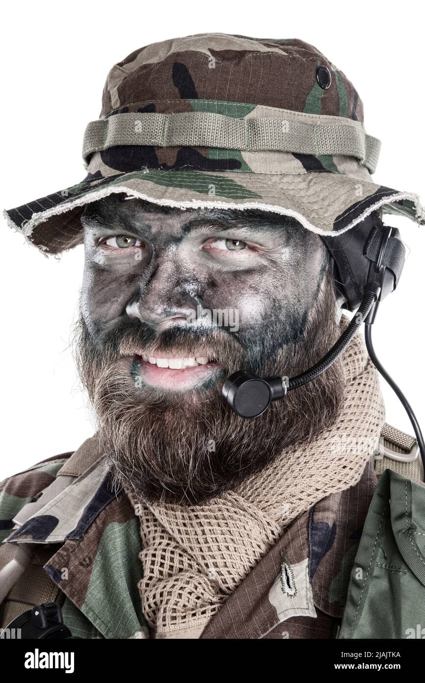 Bearded commando soldier with camouflage face paint, wearing a tactical ...