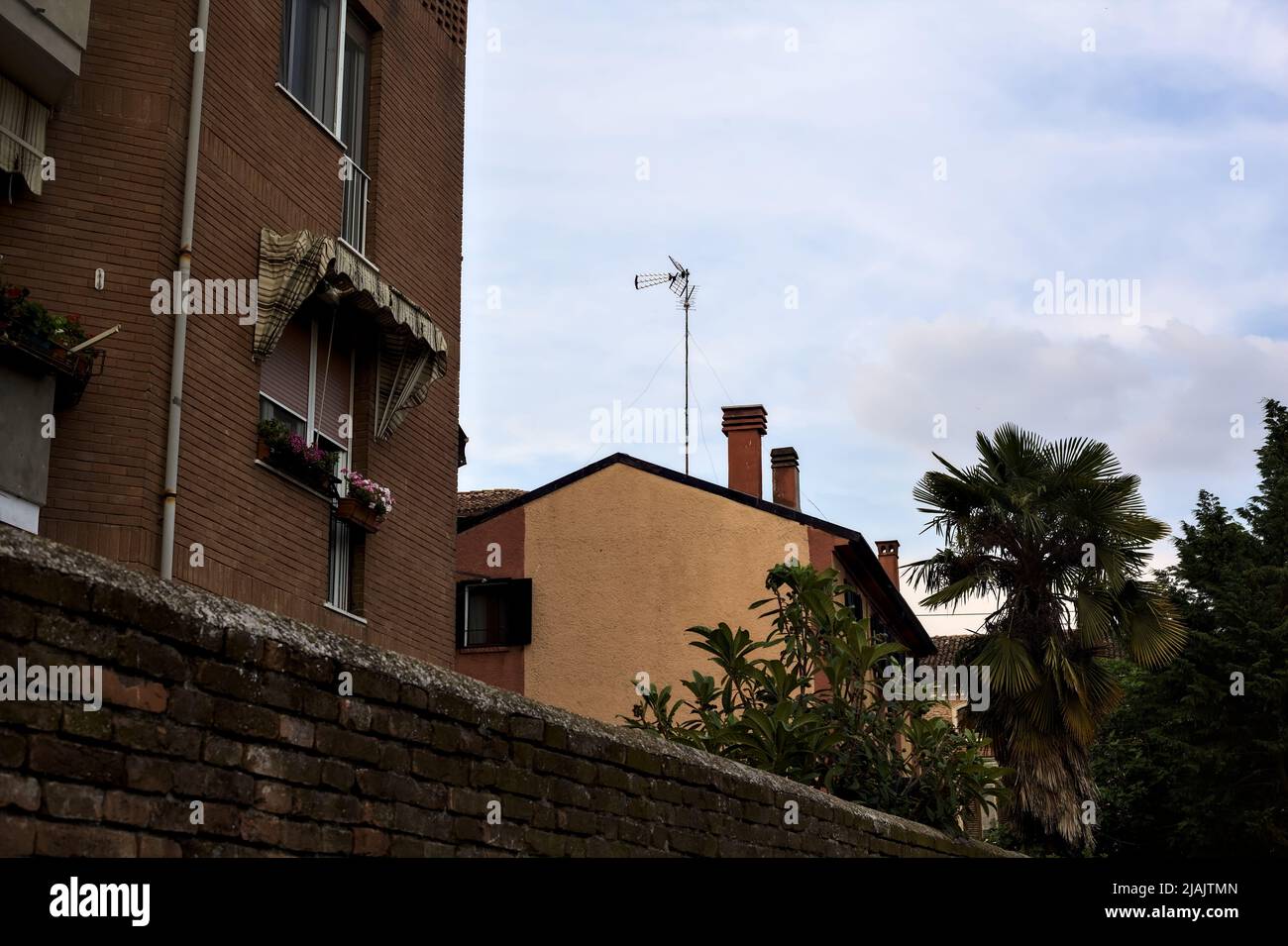 Buildings with blaconies and a palm tree on a cloudy day Stock Photo ...