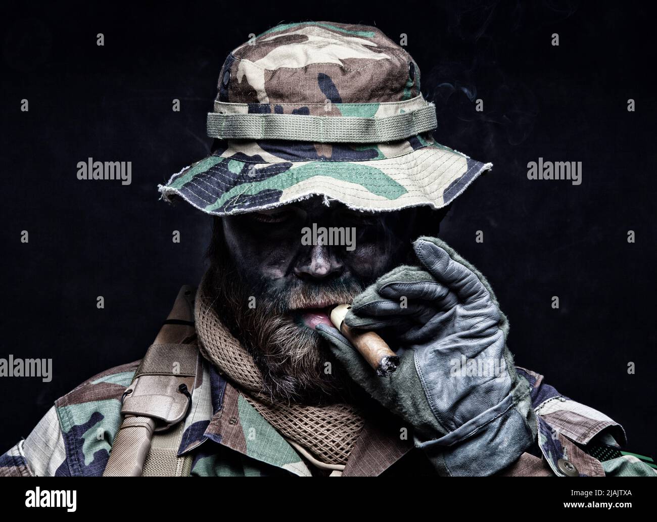 Commando soldier in boonie hat smoking a cigar, studio portrait on ...