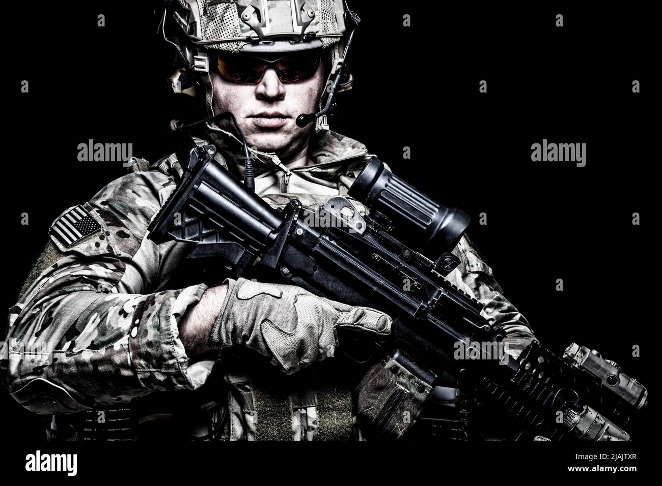 U.S. soldier armed with assault rifle, studio portrait on black ...