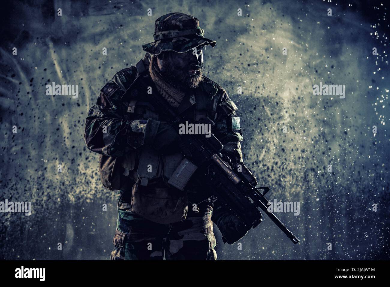 Commando fighter with assault rifle, sneaking in the darkness ready to ...