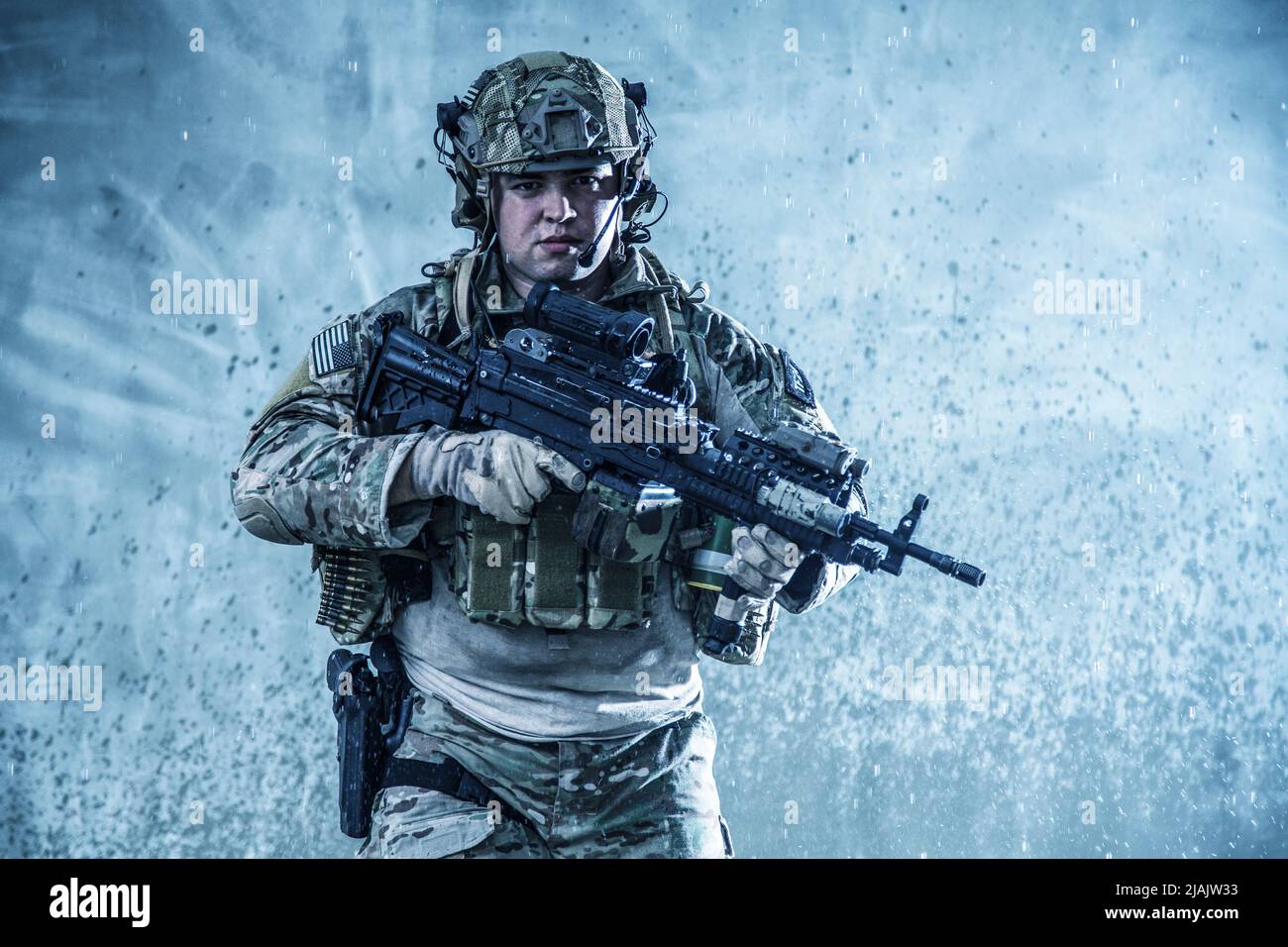 U.S. Marine in battle uniform and helmet, armed with light machine gun ...