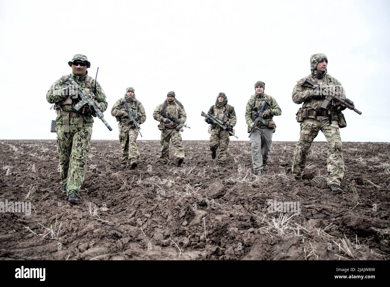 Soldiers walking on muddy terrain Stock Photo - Alamy
