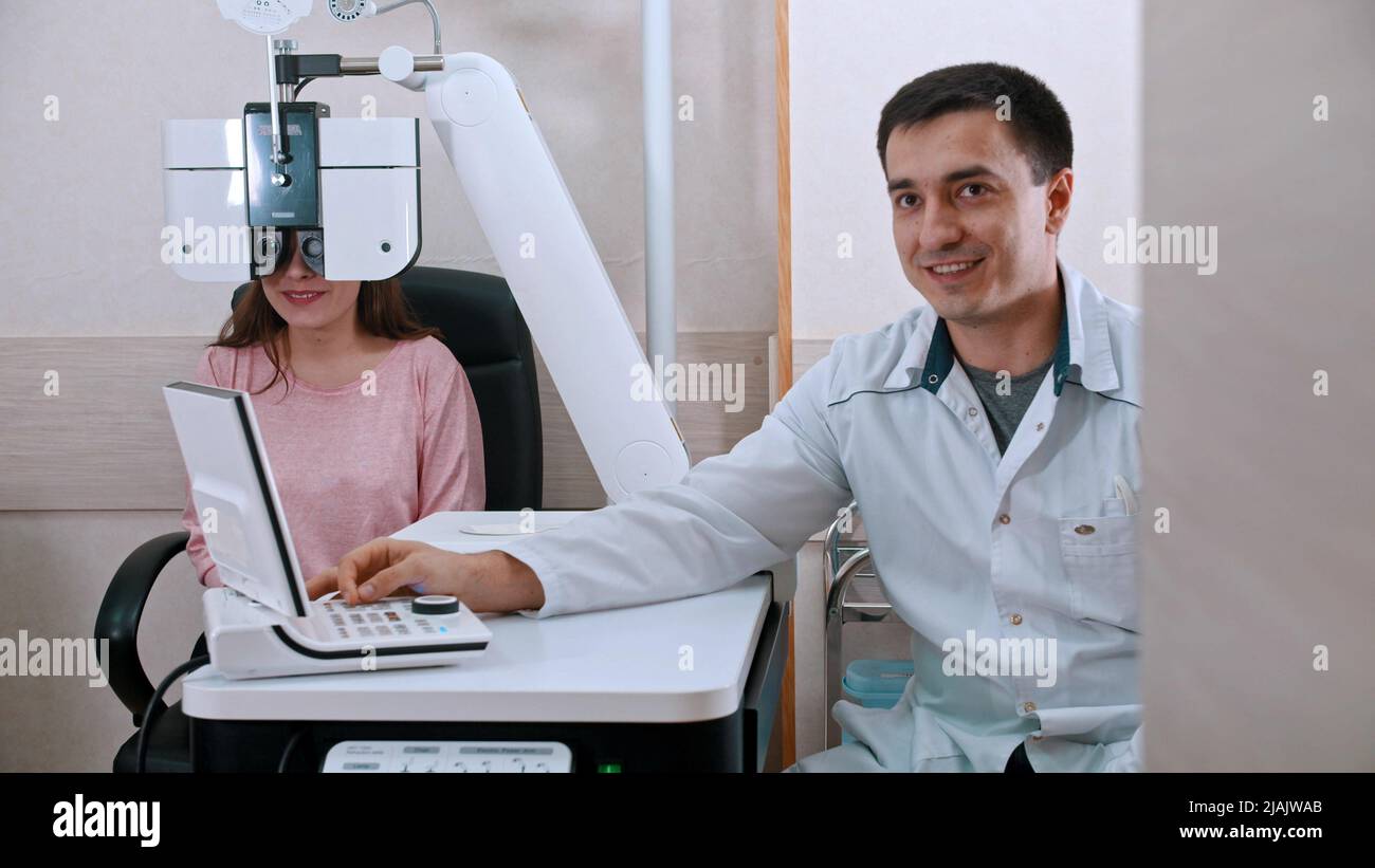 Ophthalmology - young woman checking her visual acuity with an ...