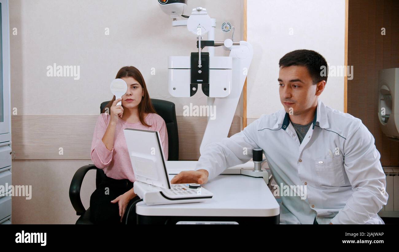 Ophthalmology - young woman checking her visual acuity - closing an eye ...