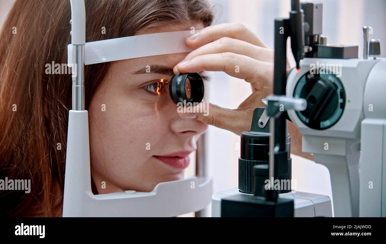 Ophthalmology treatment - a young woman with pink lips checking her ...