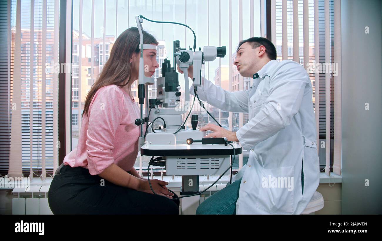 Ophthalmology - a doctor checking young pretty woman visual acuity with ...