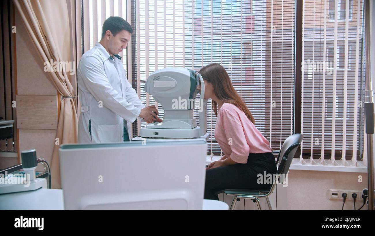 Ophthalmology treatment - young woman checking her visual acuity with a ...