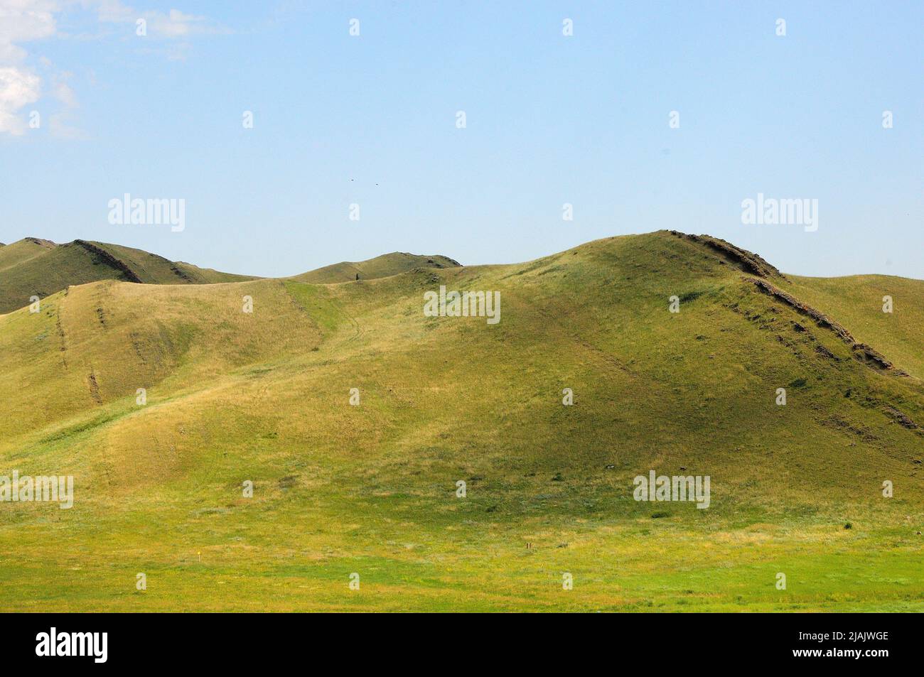 A range of high hills with a stone formation running along the top ...