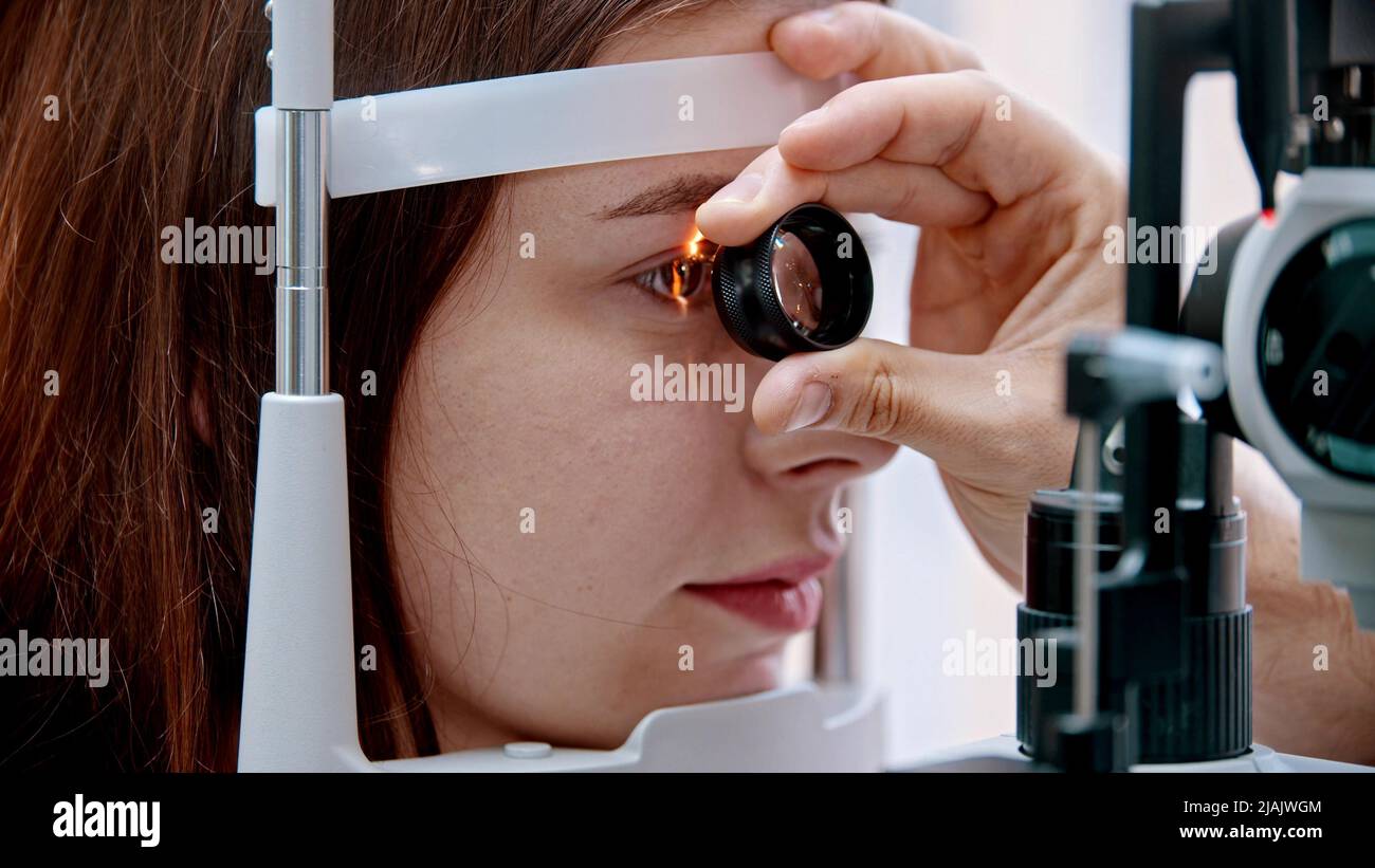 Ophthalmology treatment - a young woman checking her visual acuity with ...