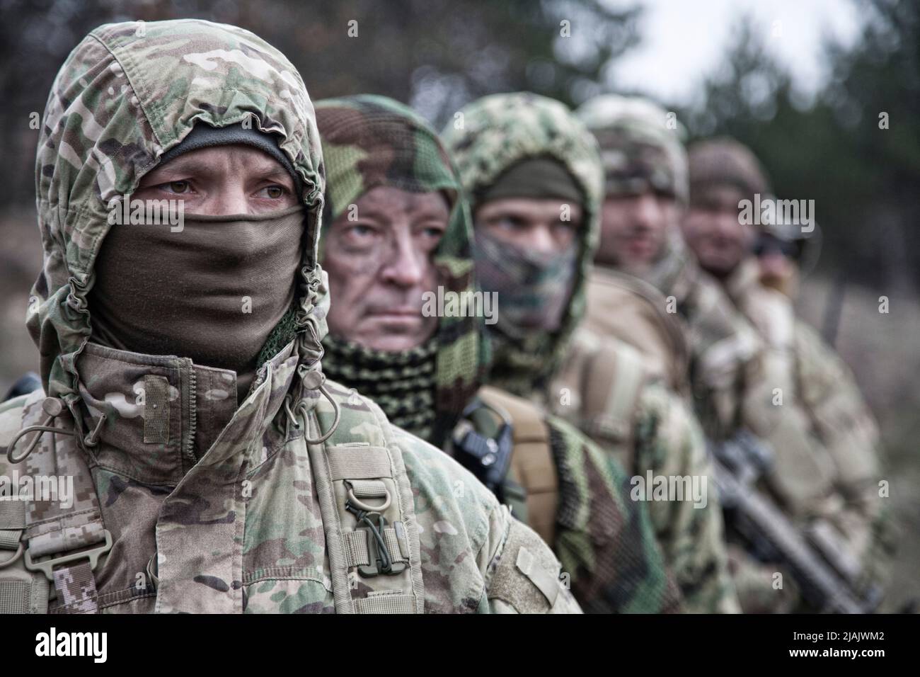 Group of skilled commandos wearing camouflage uniforms and masks ...