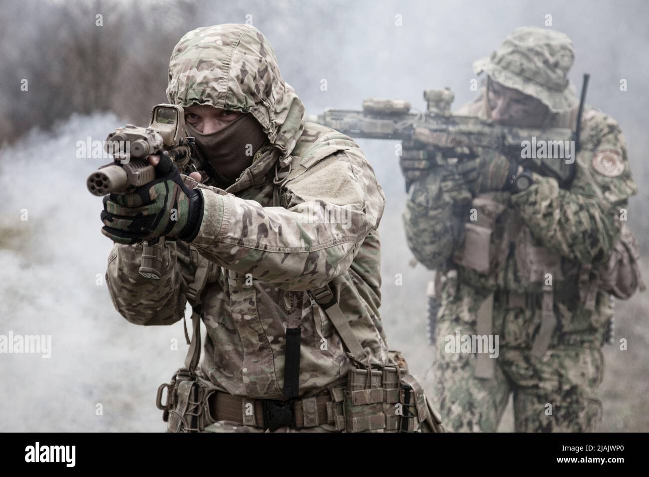 Two soldiers covering for each other, attacking enemies through a smoke ...