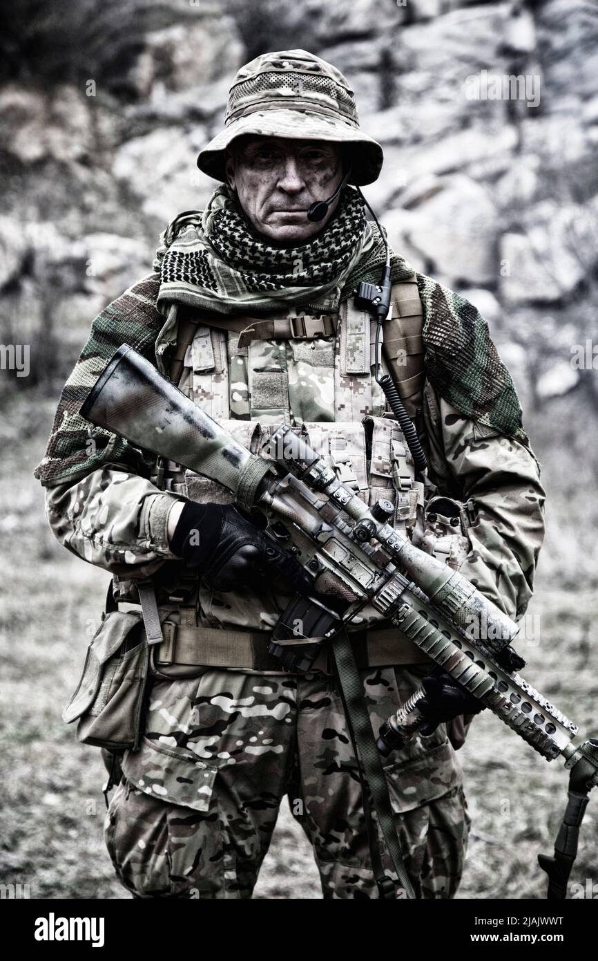 Skilled marksman in camouflage combat uniform, standing with sniper ...