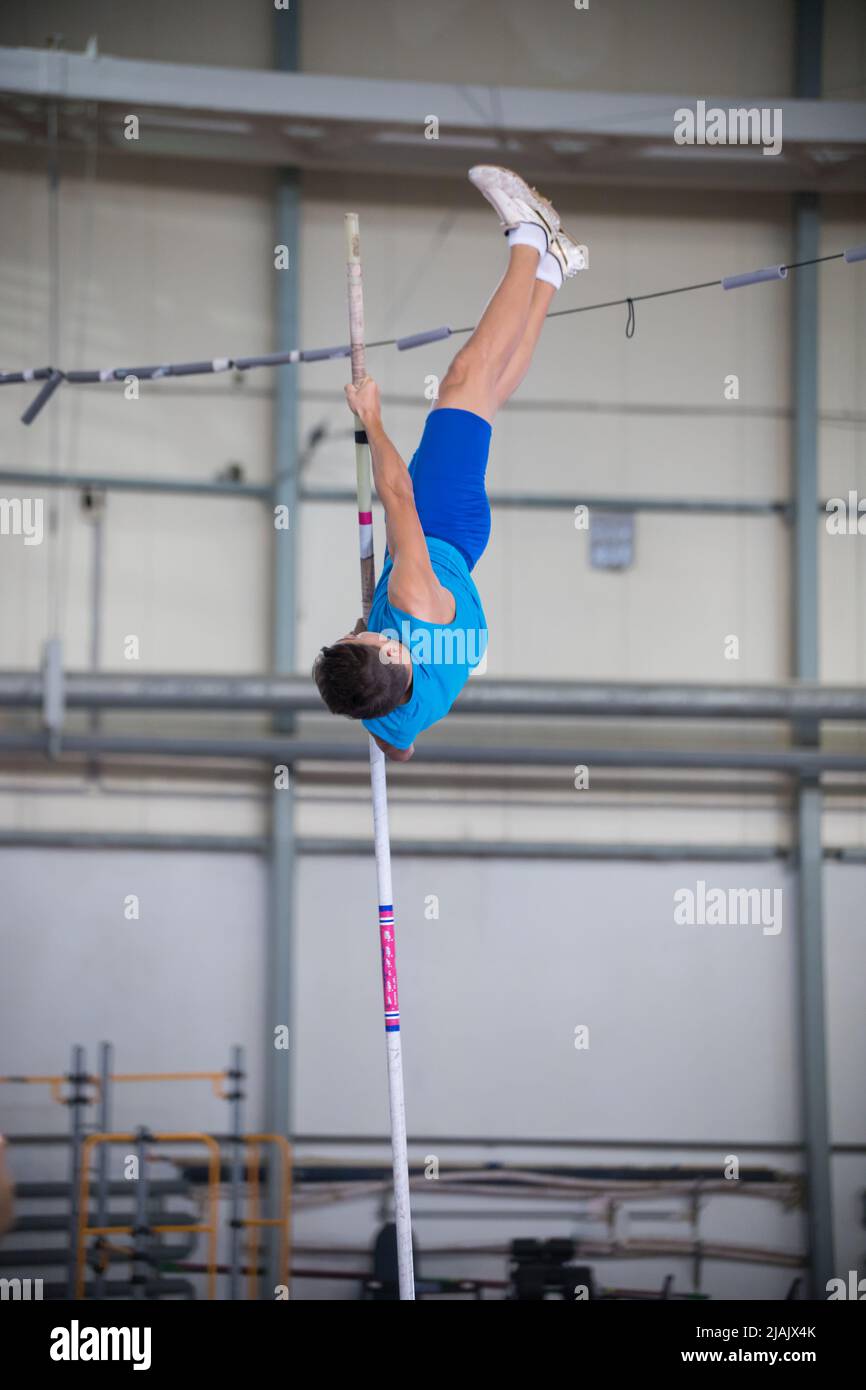 Pole vaulting indoors - young man jumping over the partition - leaning ...