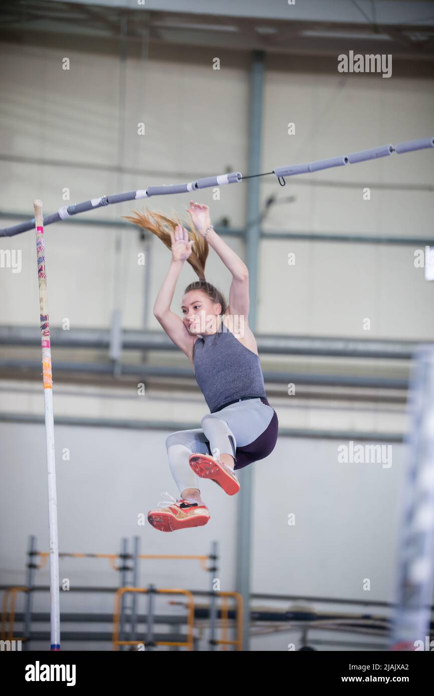 Pole vaulting indoors - young sportive woman falling down after the ...