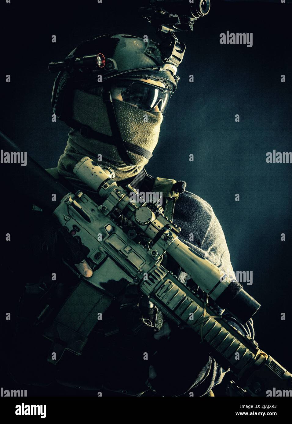 Sniper wearing face mask and helmet with thermal imager, holding rifle ...