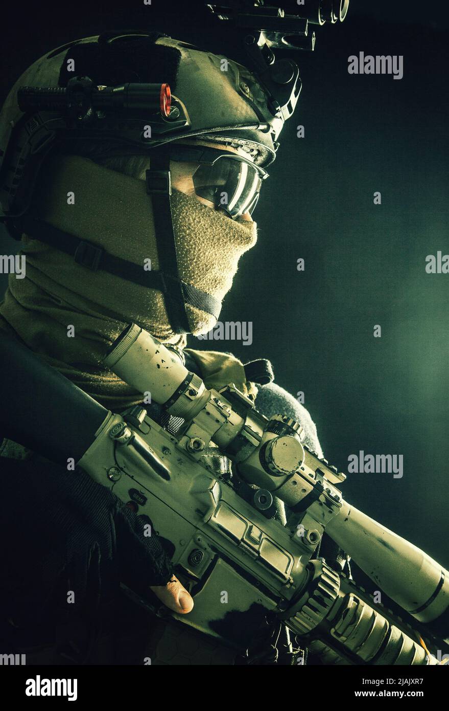 Sniper wearing face mask and helmet with thermal imager, holding rifle ...