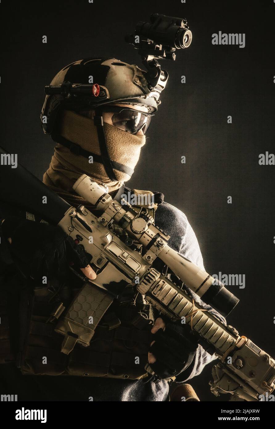 Sniper wearing face mask and helmet with thermal imager, holding rifle ...
