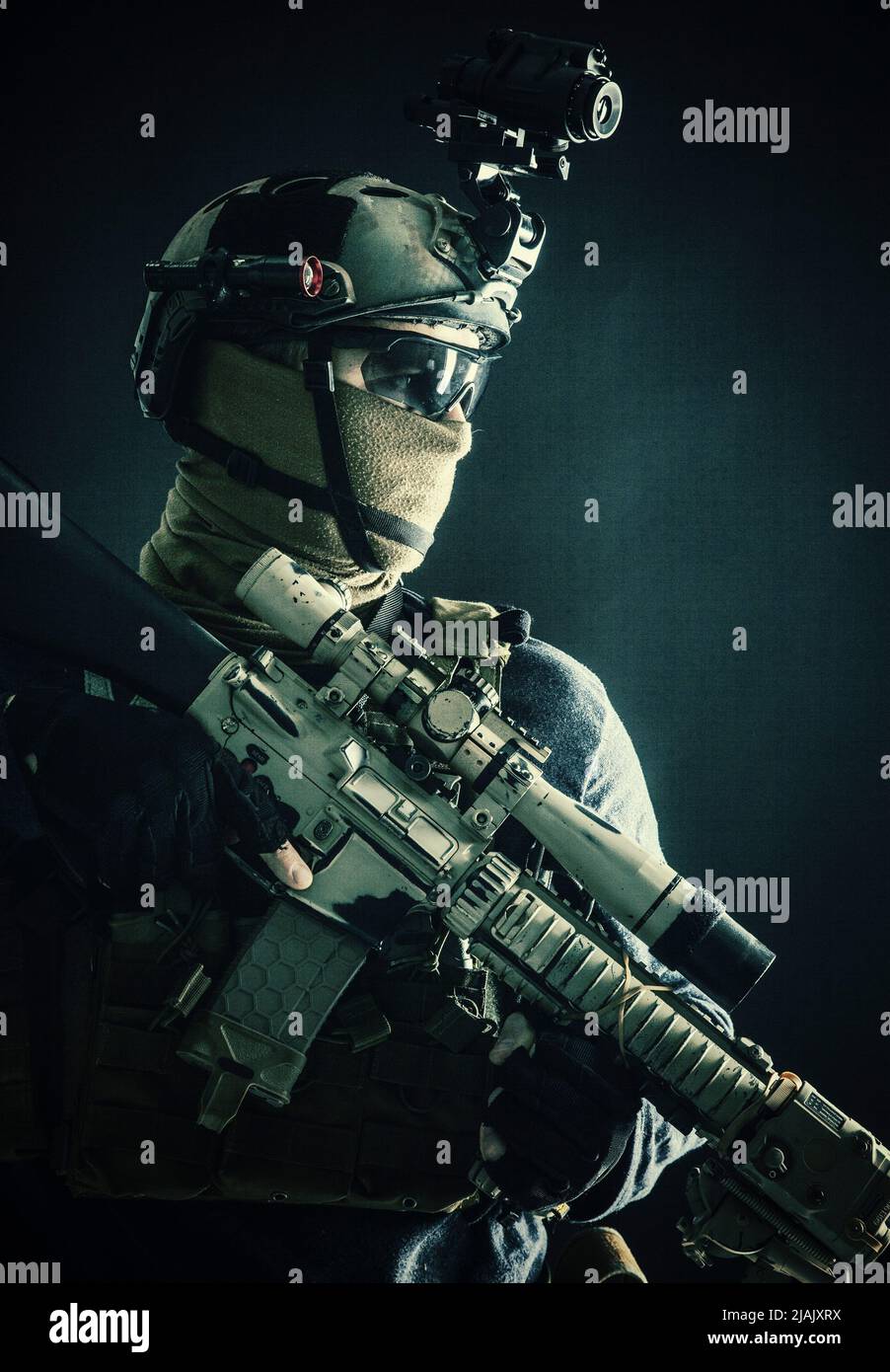 Sniper wearing face mask and helmet with thermal imager, holding rifle ...