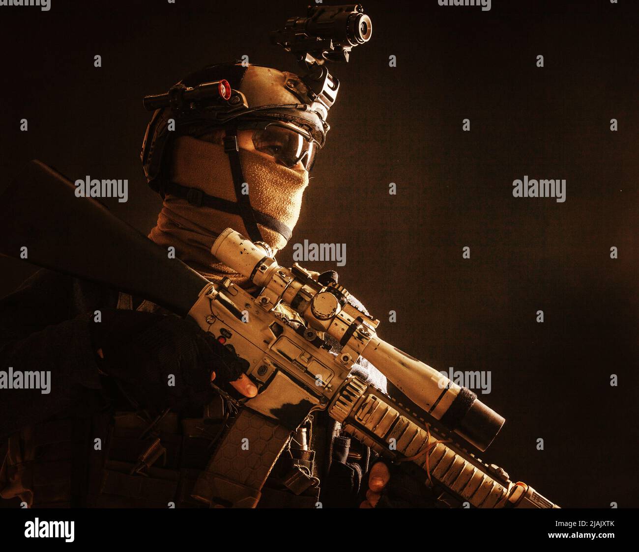 Sniper wearing face mask and helmet with thermal imager, holding rifle ...