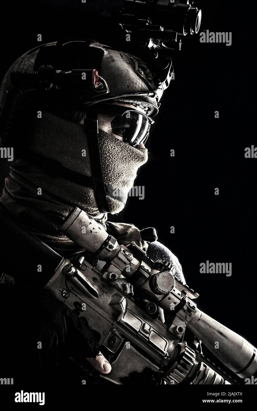 Sniper wearing face mask and helmet with thermal imager, holding rifle ...