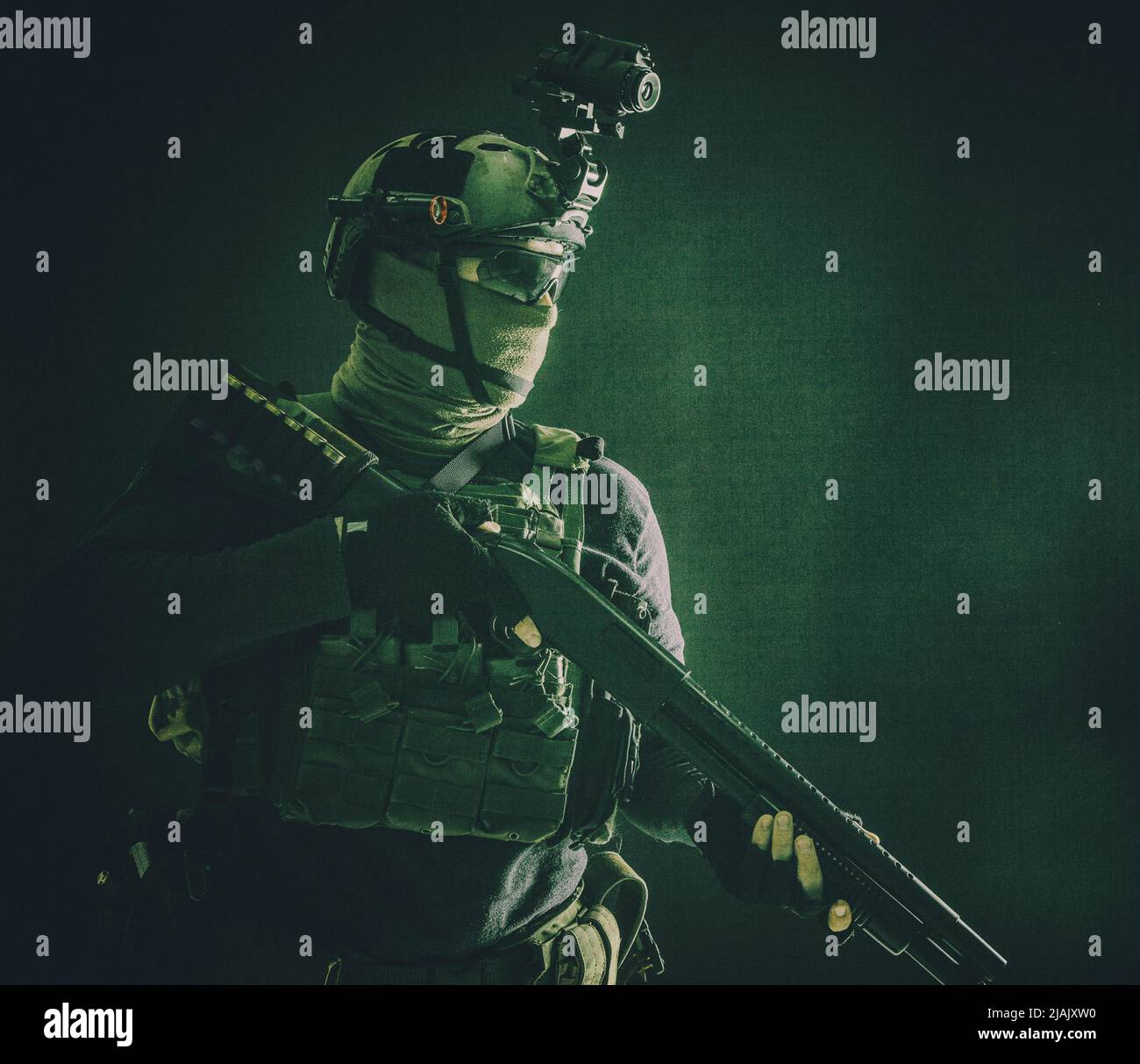 Low key studio shot of an elite soldier with shotgun, wearing face mask ...