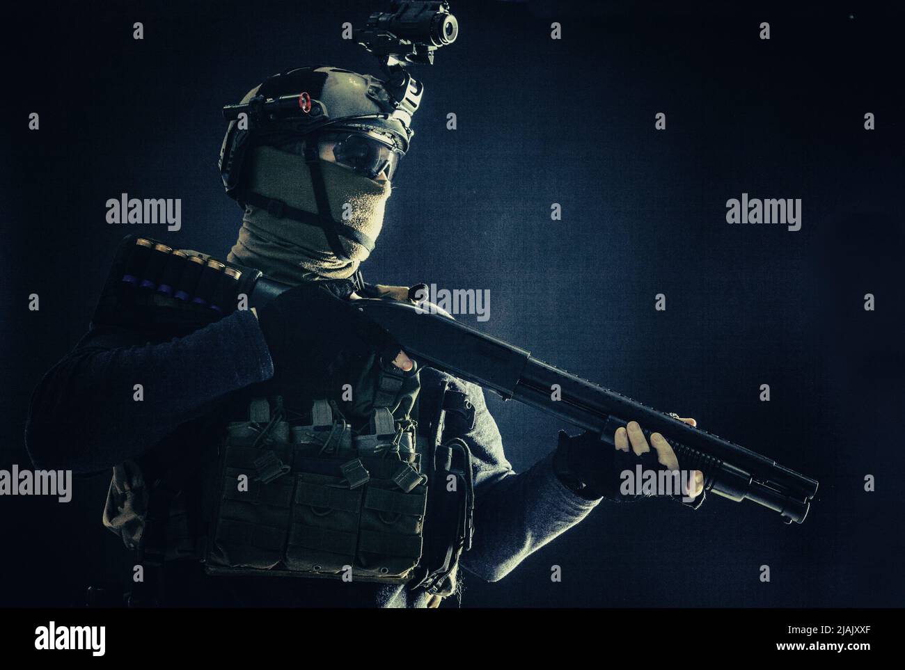 Low key studio shot of an elite soldier with shotgun, wearing face mask ...