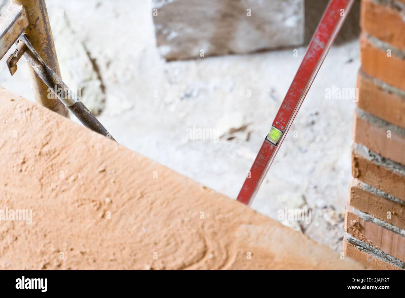 Construction level of red color at a construction site stale on a brick ...