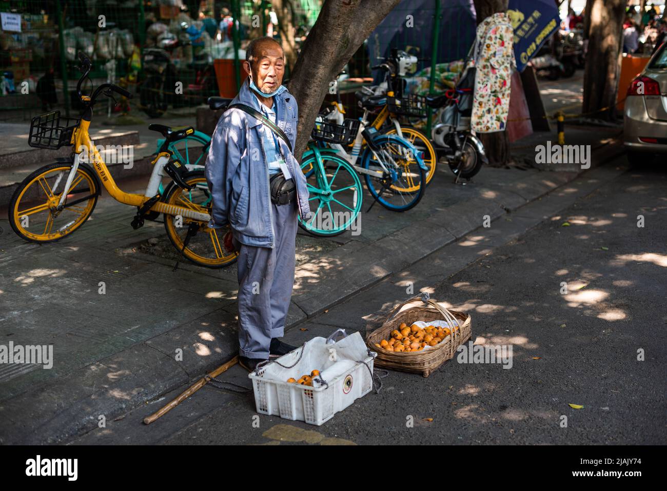 Chinese senior man selling Loquat in the street Stock Photo - Alamy
